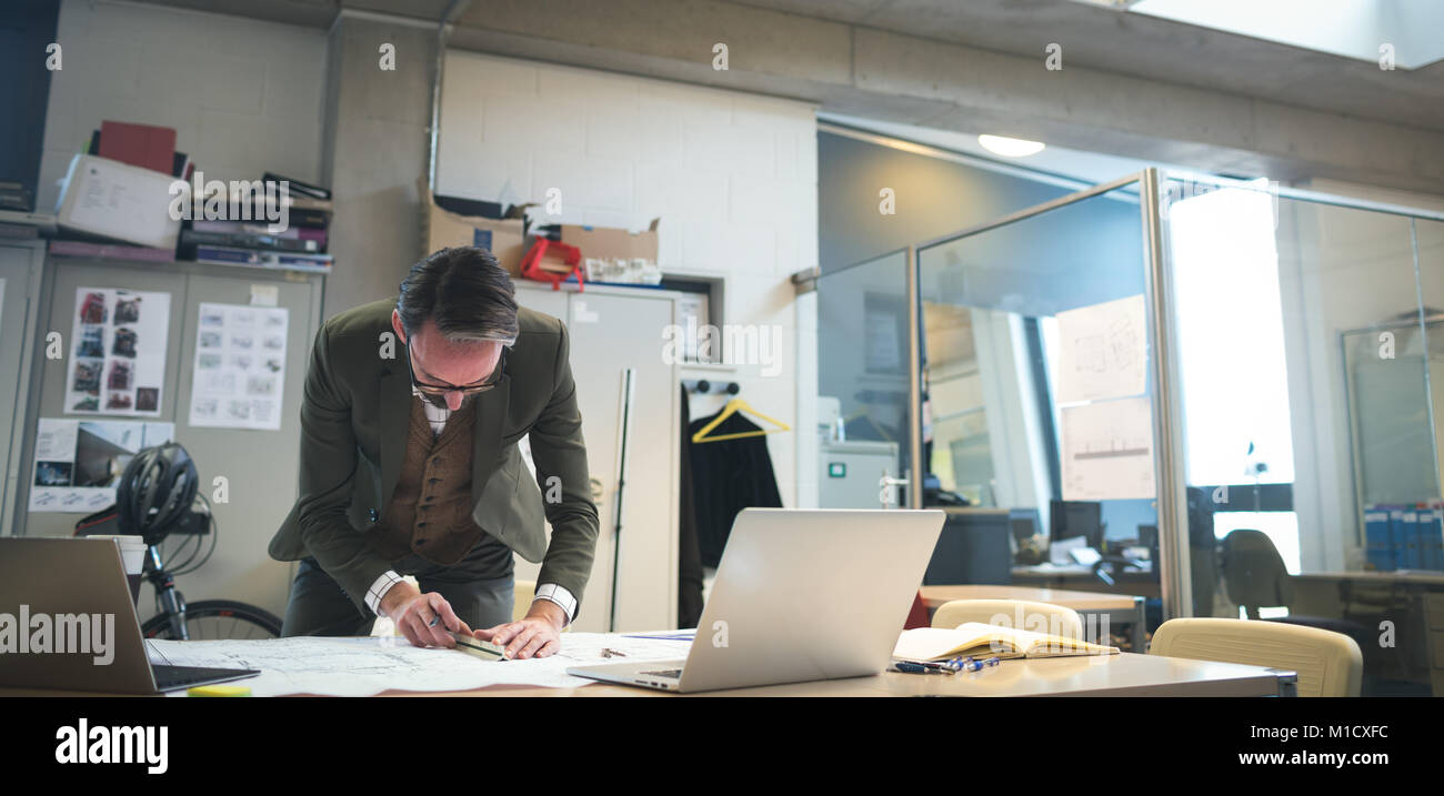 Business executive working on blueprint Stock Photo - Alamy