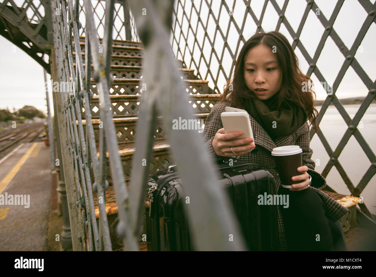 Woman using mobile phone on staircase Stock Photo - Alamy