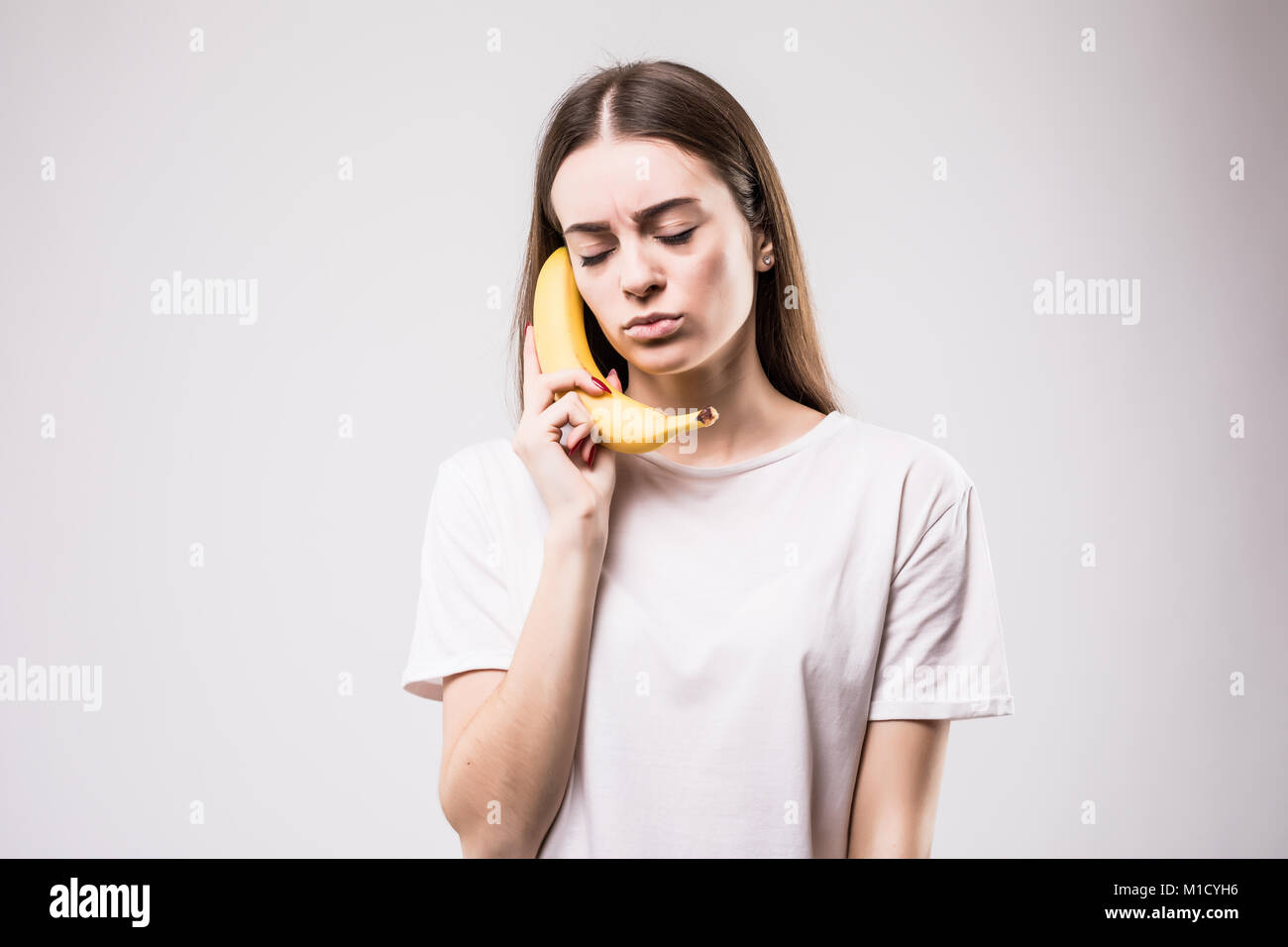 woman calling with a banana on a white background Stock Photo - Alamy
