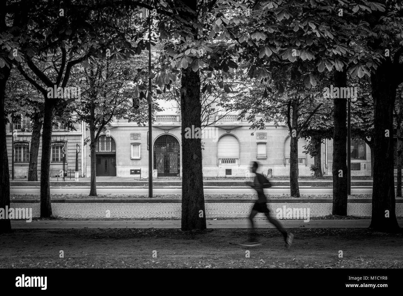 Black and white shot of unrecognizable blurred man running on street ...
