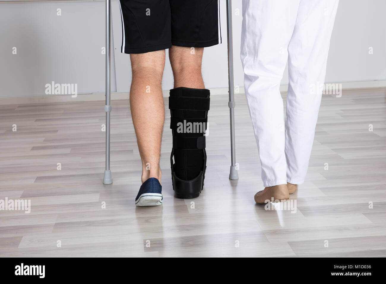Low Section View Of Physiotherapist And Injured Person's Leg Wearing ...
