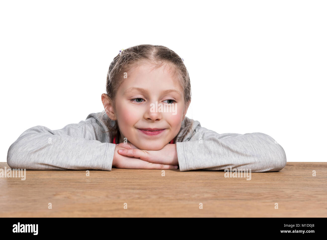 Portrait of a small beautiful girl leaning on the arm sitting at a ...