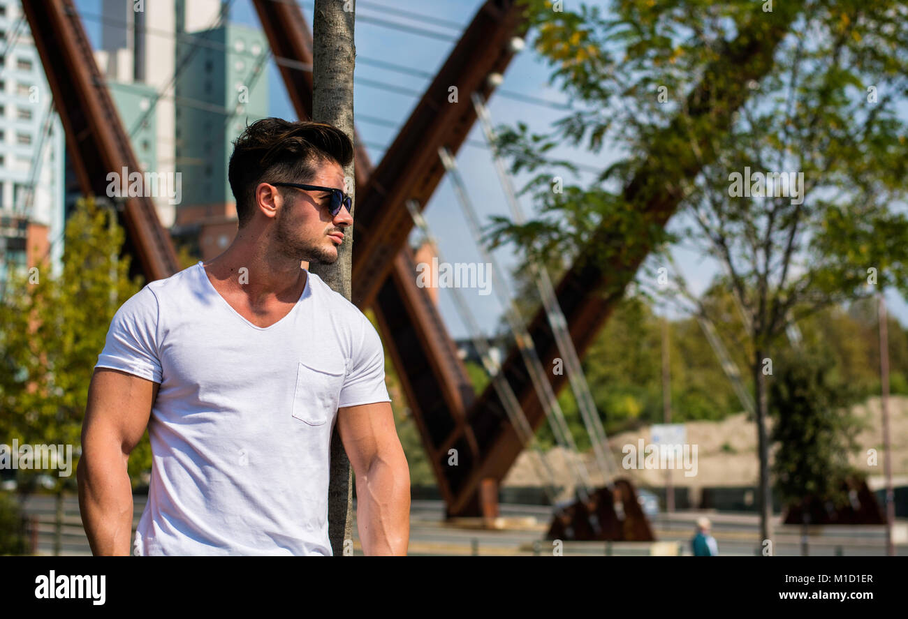Attractive man in urban setting in front of big metal structure Stock ...