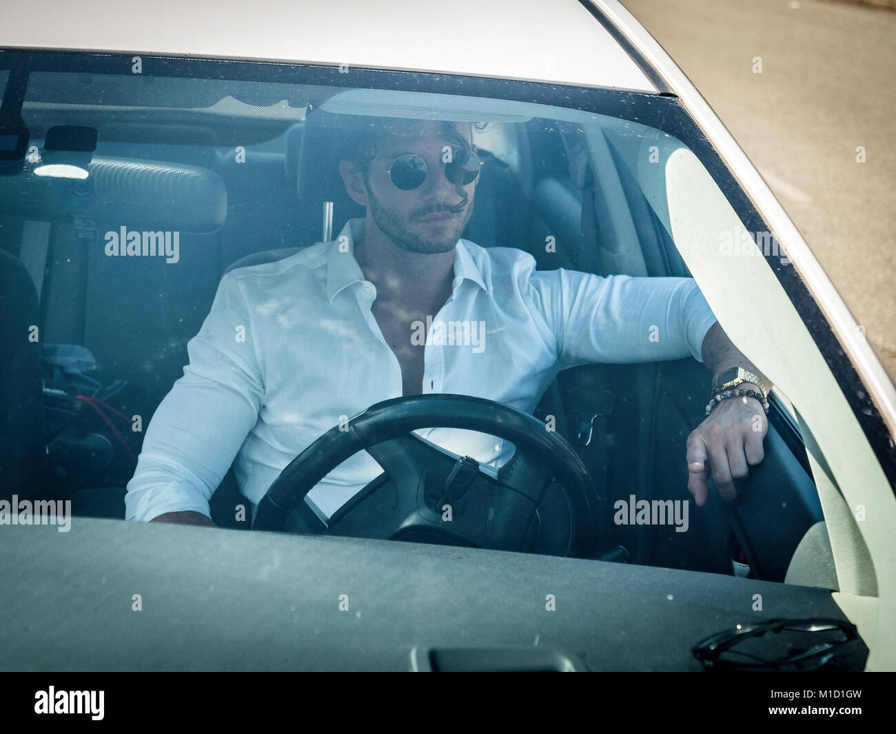 Handsome Man Behind the Wheel Driving a Car, wearing white shirt, hand ...