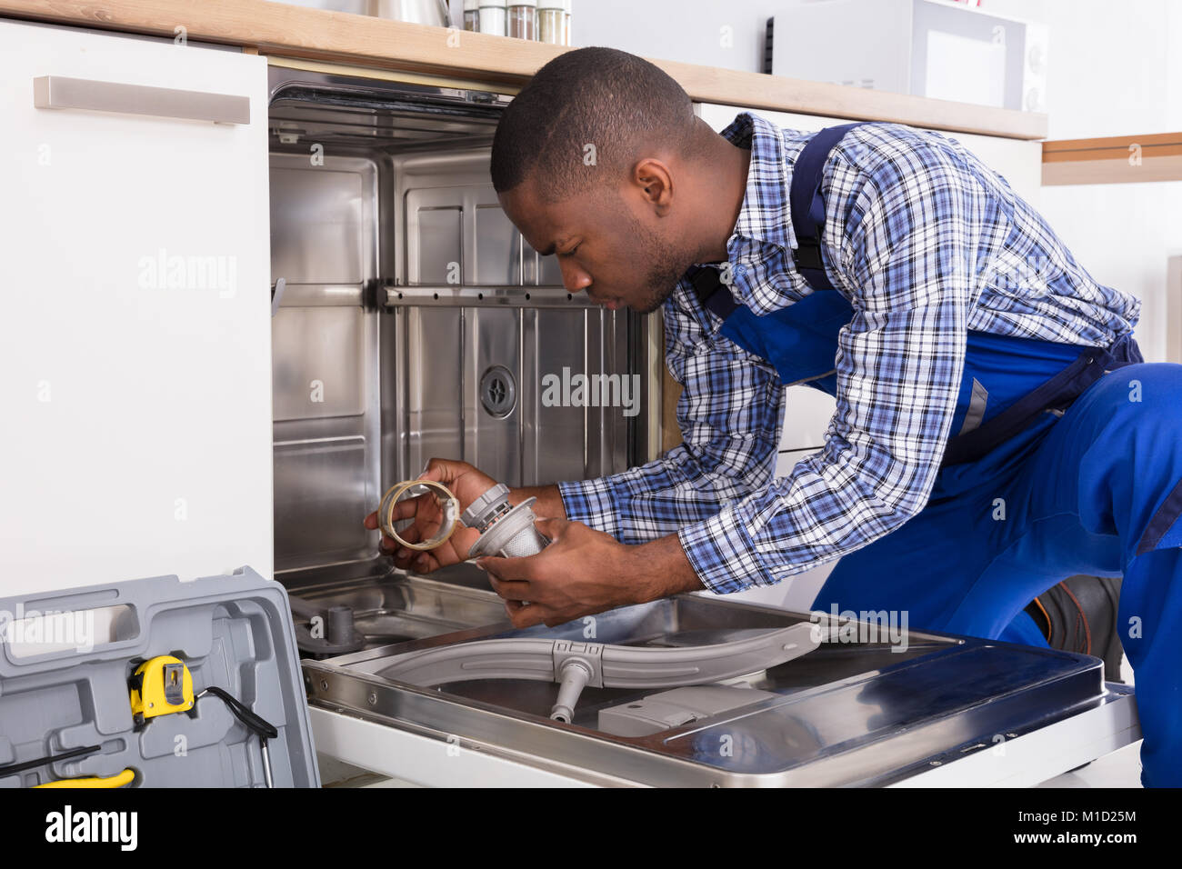 Technician installing repairing dishwasher in hi-res stock photography ...