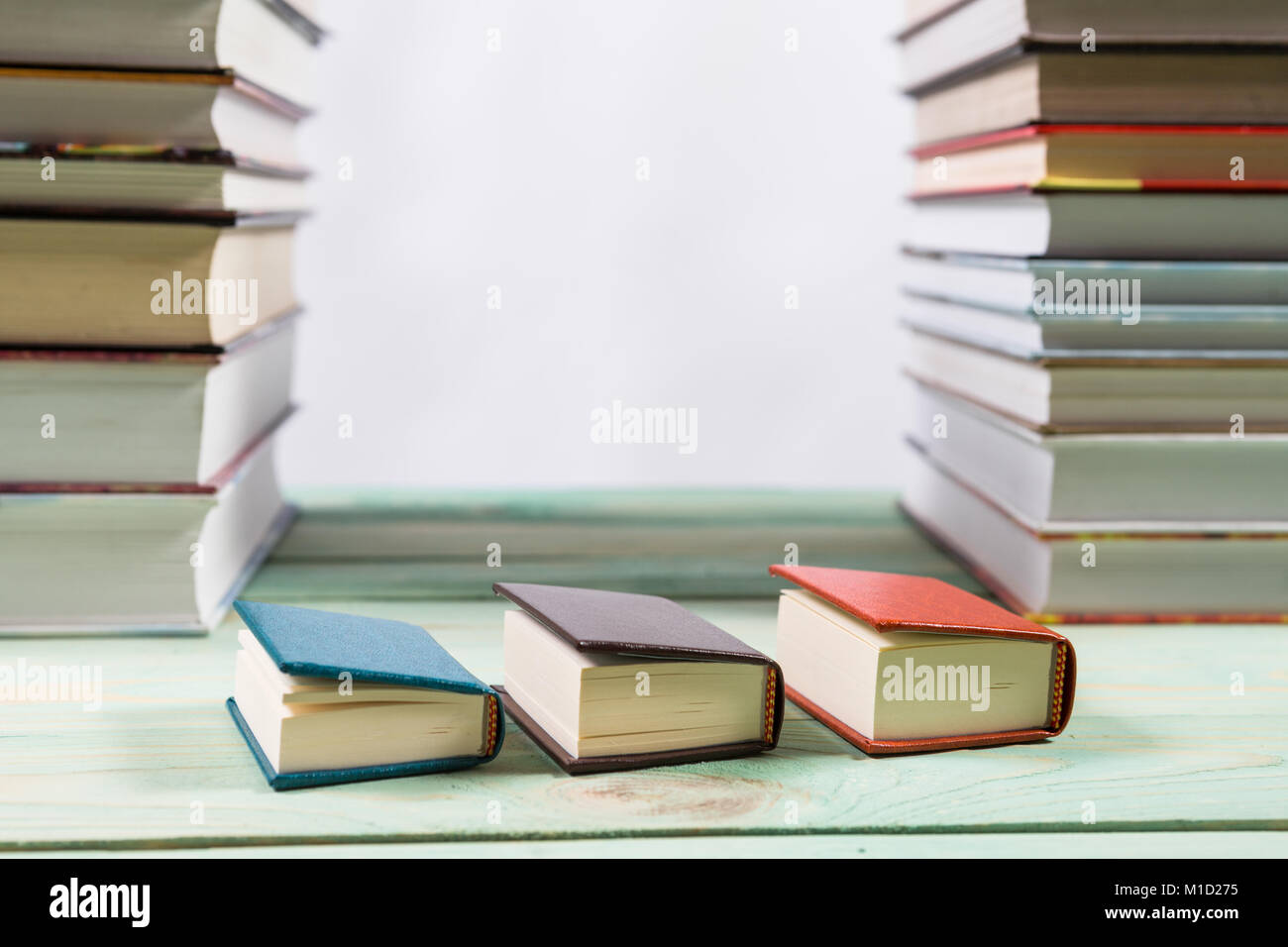 Pile of various books on bright wooden background. With copy space for ...