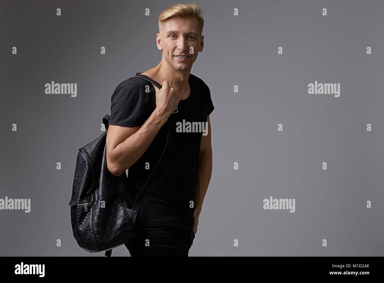 Portrait smilingyoung man with backpack Stock Photo - Alamy