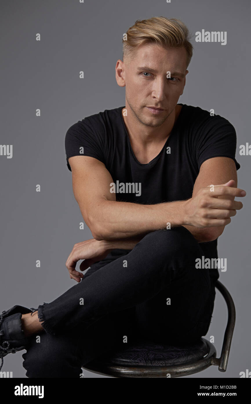 Portrait young stylish man model sitting leg over leg thoughtful Stock ...