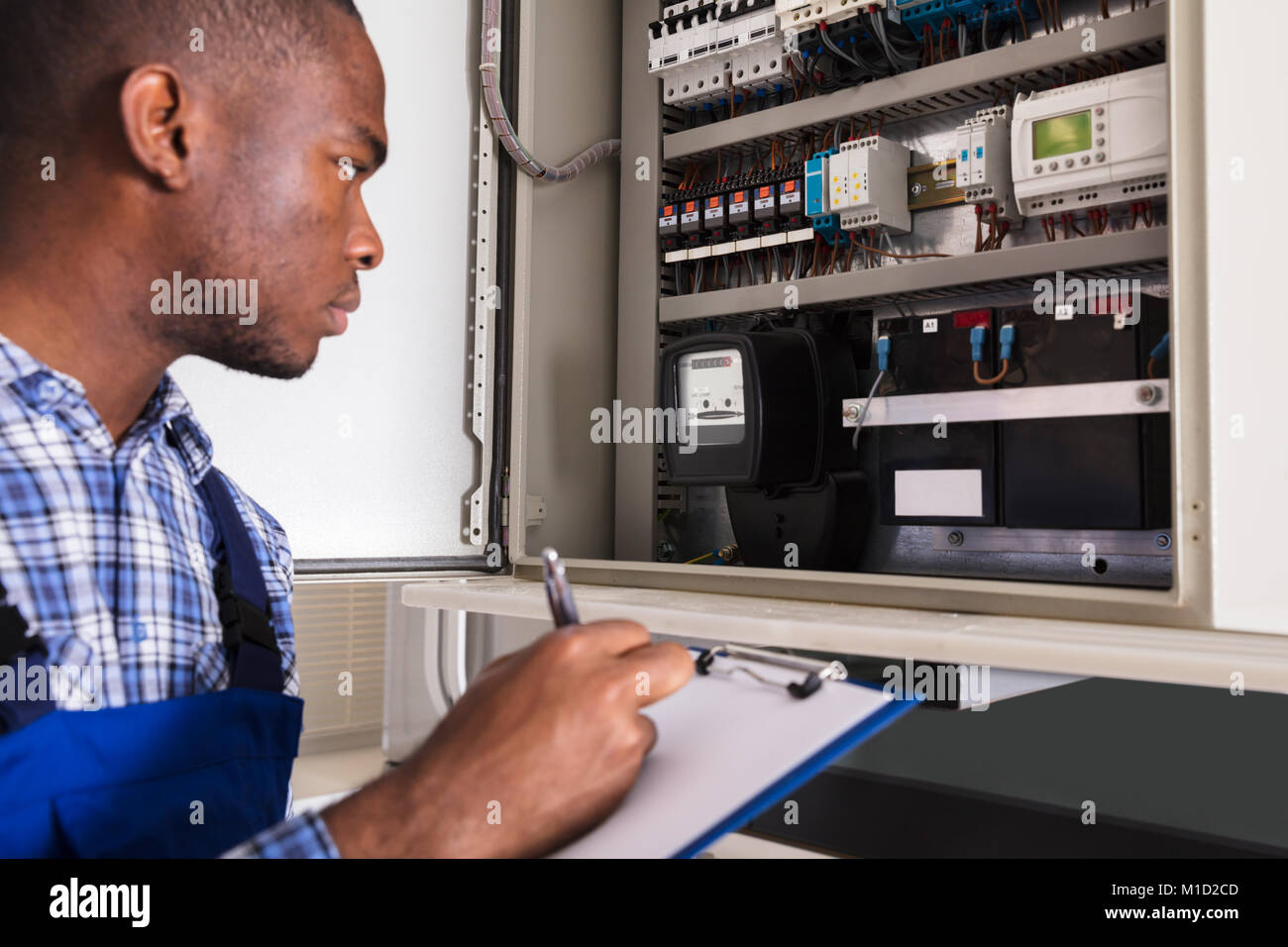 Close-up Of Male Technician Writing On Clipboard In Front Of Fuse Box ...