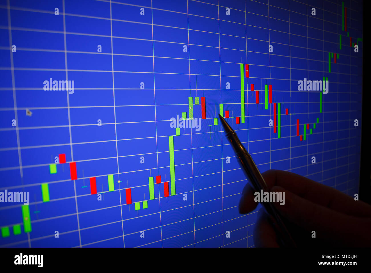 Financial graph on a computer monitor screen. Businessman writing the ...