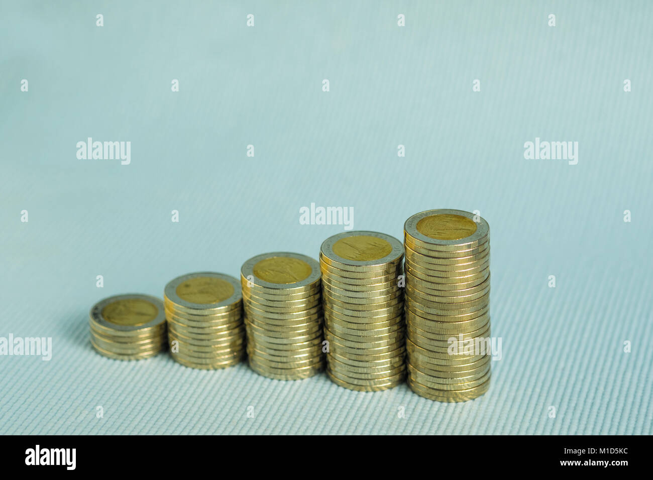Increasing columns of coins, step of coin stacks with copy space for ...