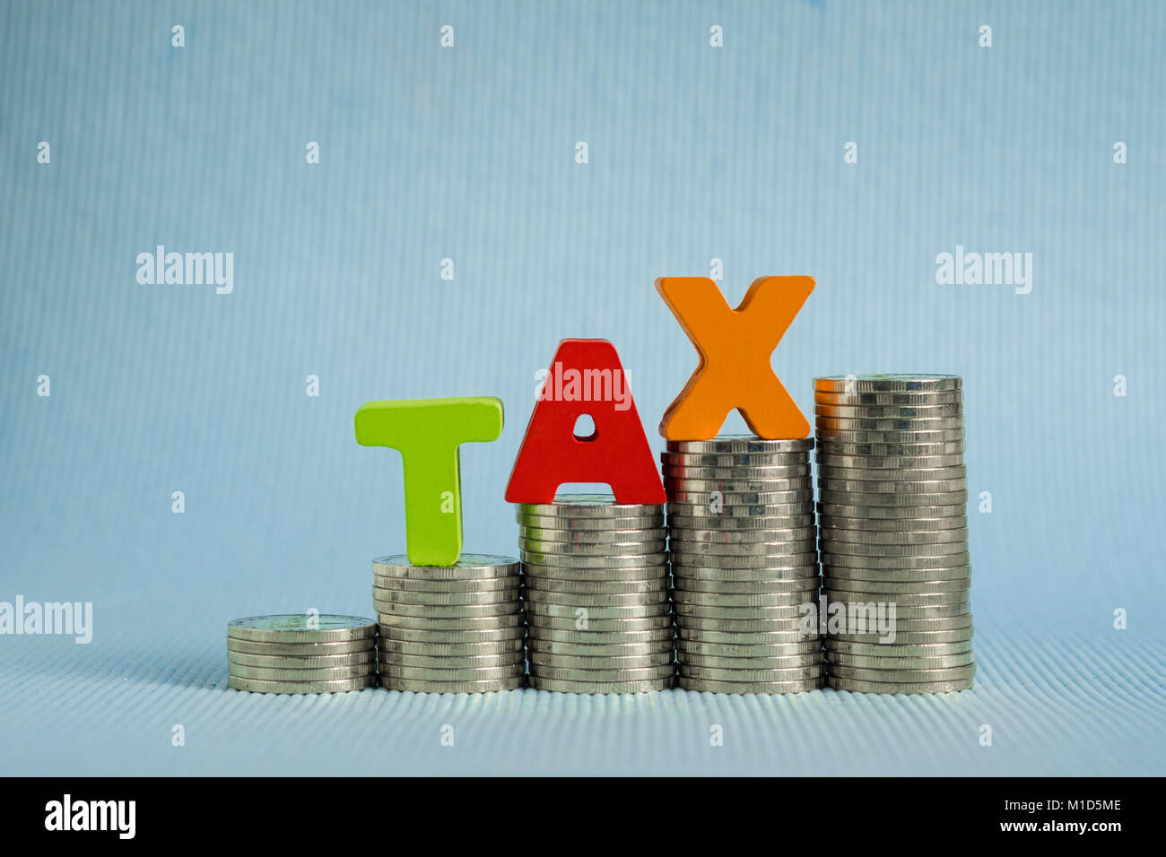 TAX concept. Word TAX alphabet made from wood with stack of coin ...