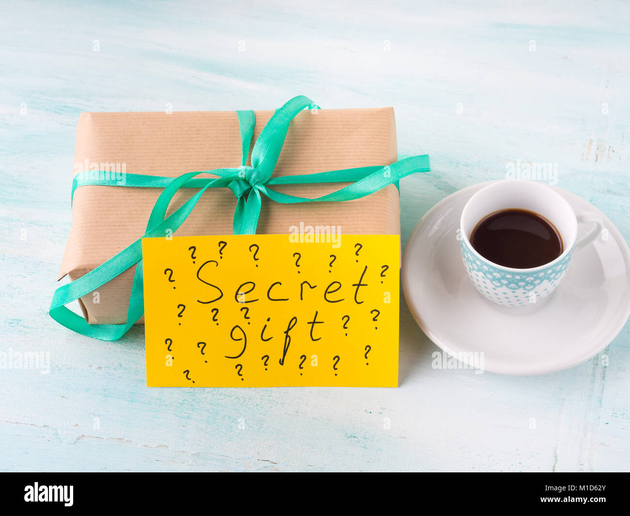 Wrapped surprise birthday holiday present box with green ribbon and cup ...