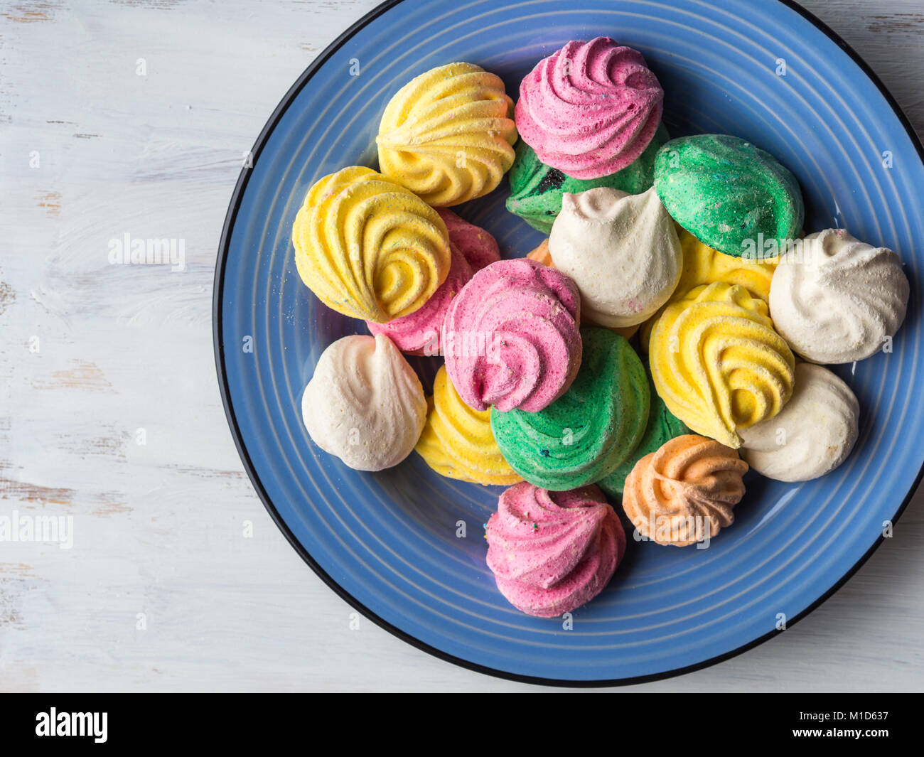Colorful pastel color meringue on blue ceramic plate. Texture Stock ...