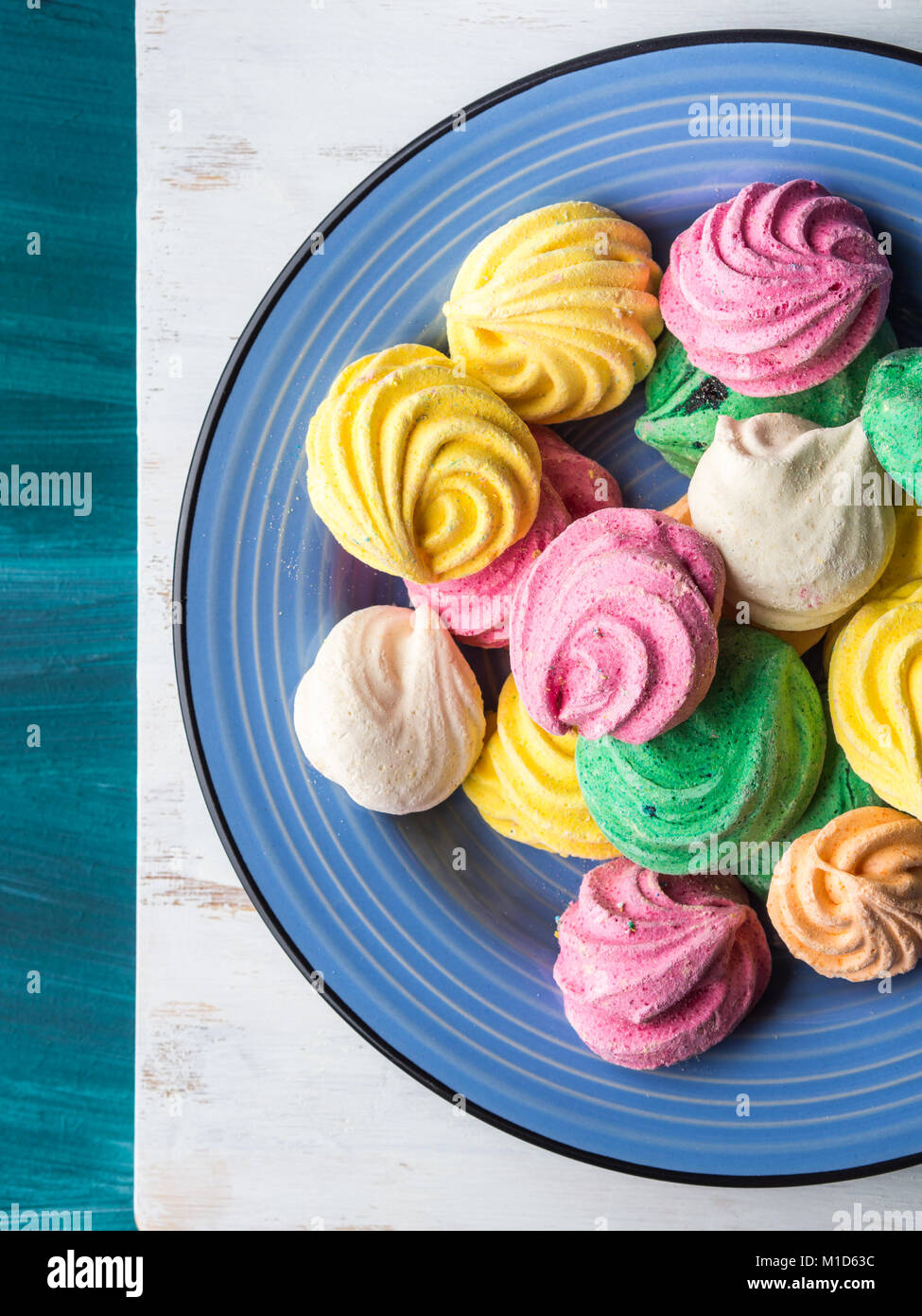 Colorful pastel color meringue on blue ceramic plate. Texture Stock ...