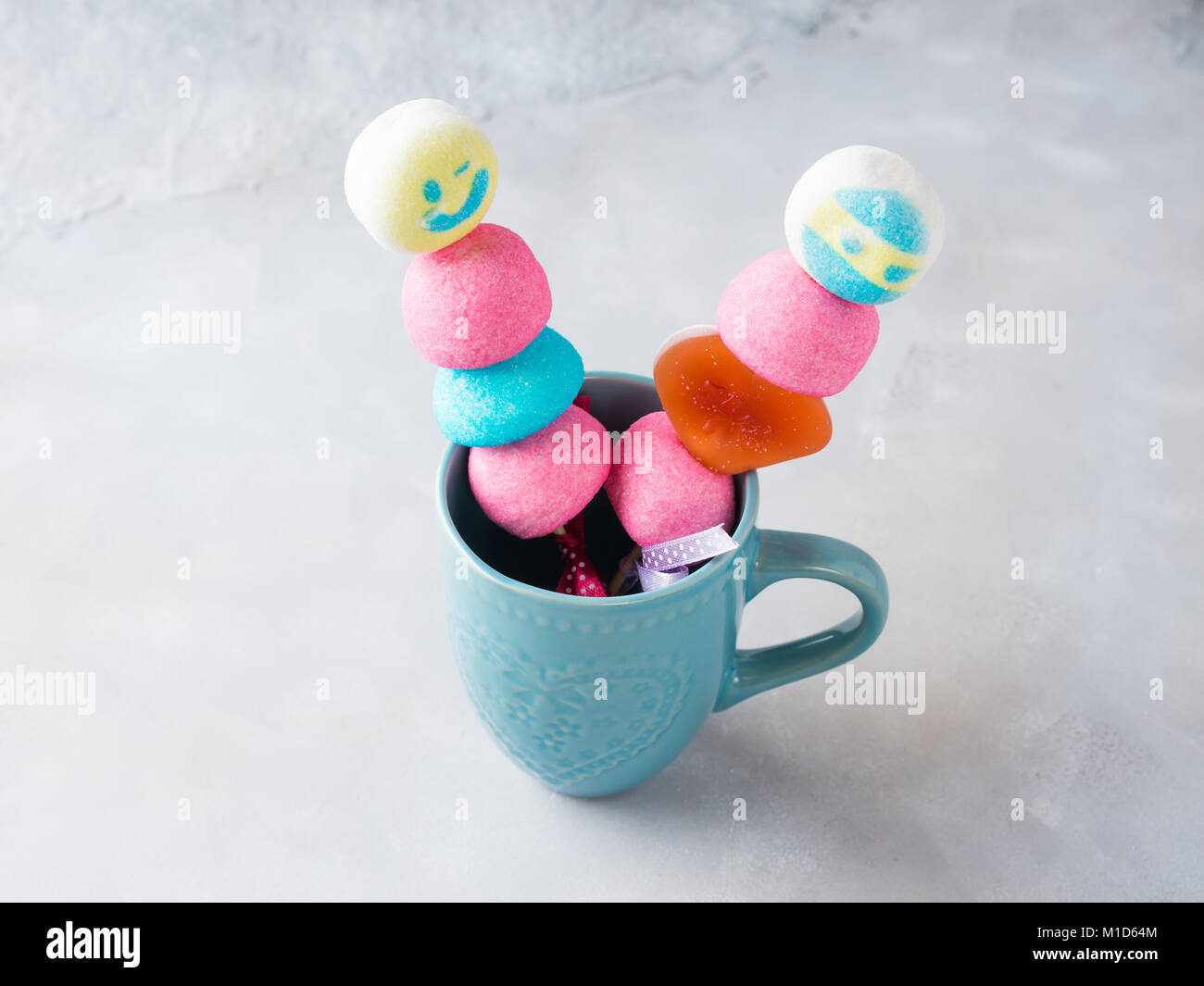 Colorful marshmallows cake pops on wooden sticks with smiling faces ...