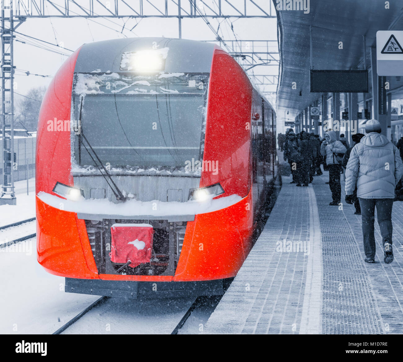 Highspeed train stands at the station platform at winter evening time ...