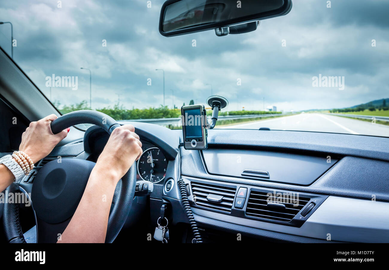 Woman driving a car and using a navigation device Stock Photo - Alamy