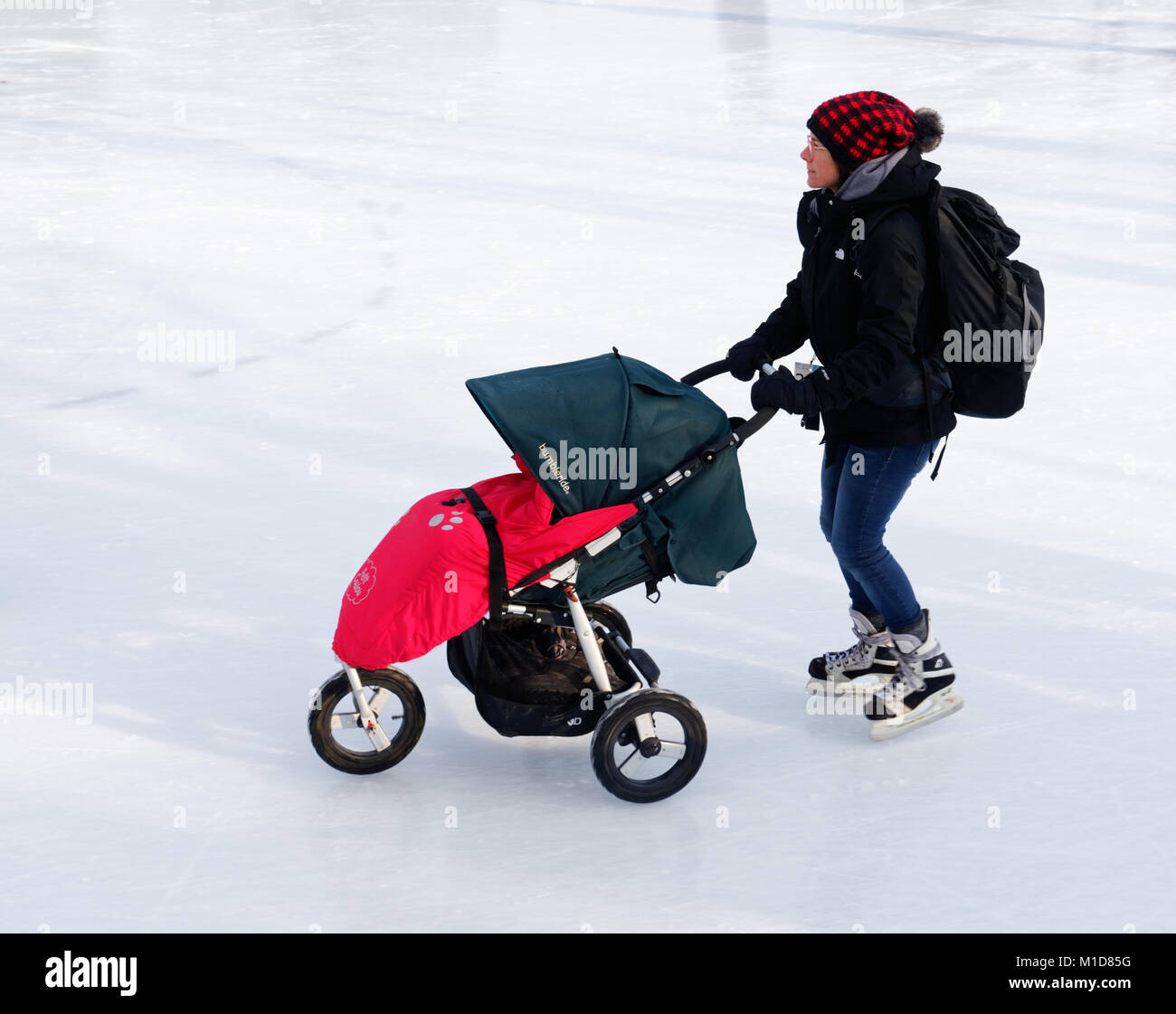 A woman ice skating pushing a pushchair on the rink in the Old Port ...