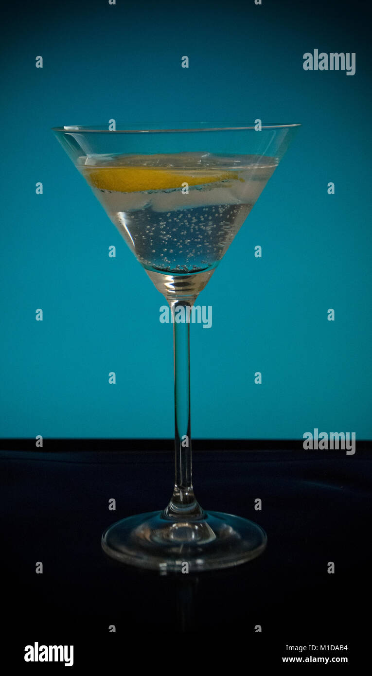 A tall glass of sparkling water with lemon on a blue background Stock ...