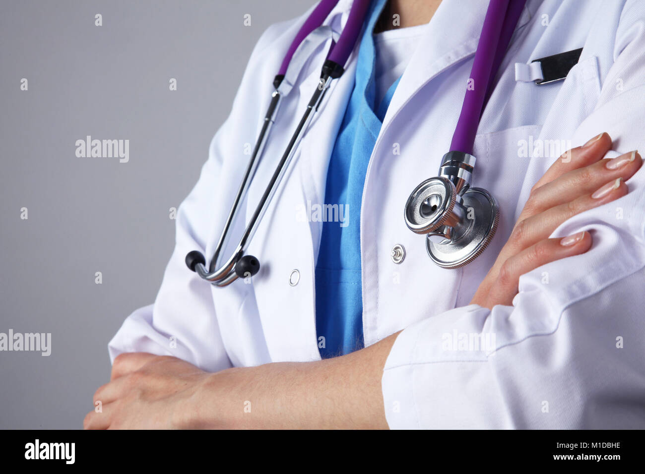 Young woman doctor standing with crossed arms, medical stethoscope ...