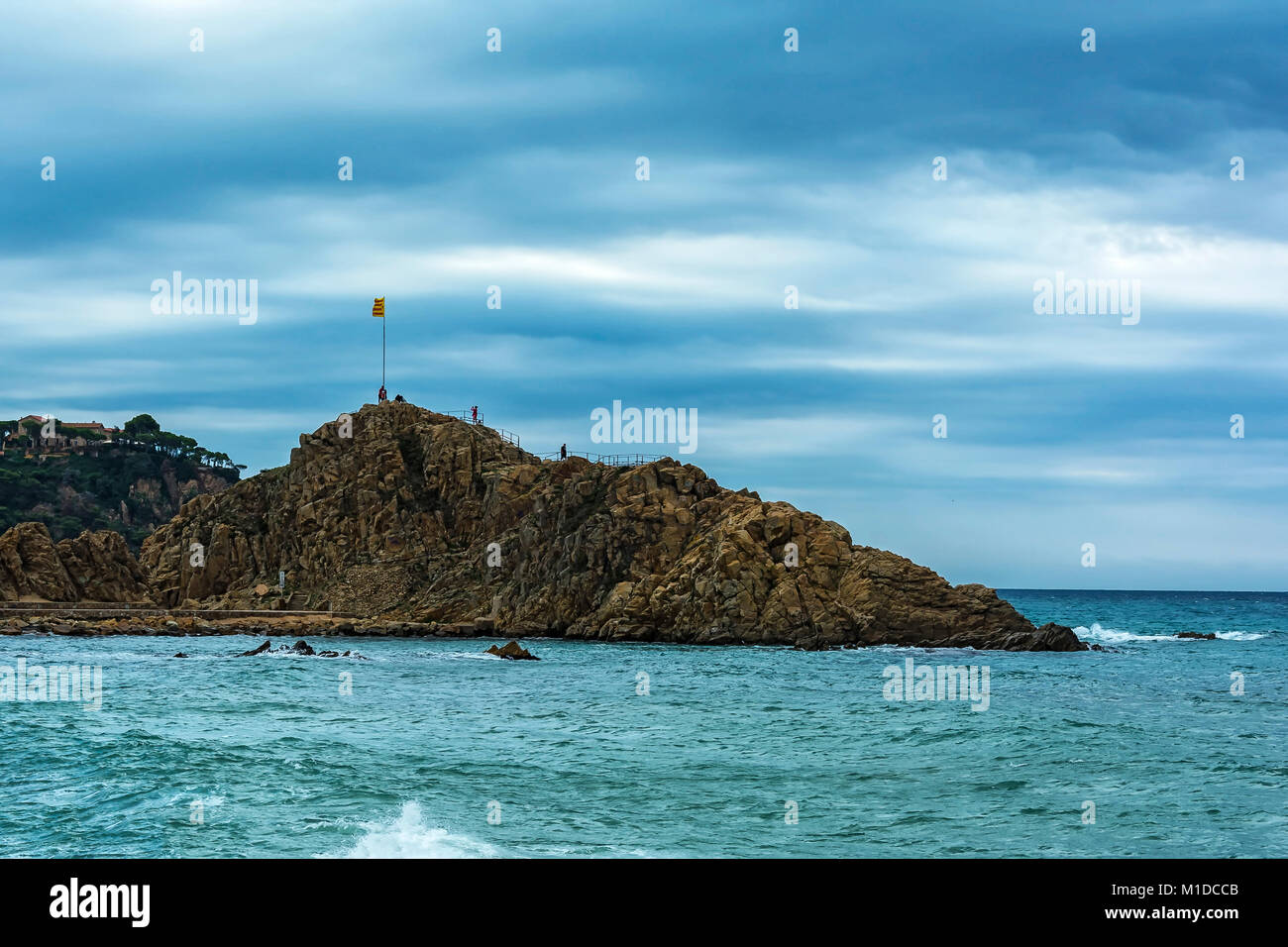 The rock Sa Palomera with the national flag of Spain at the top (Spain ...