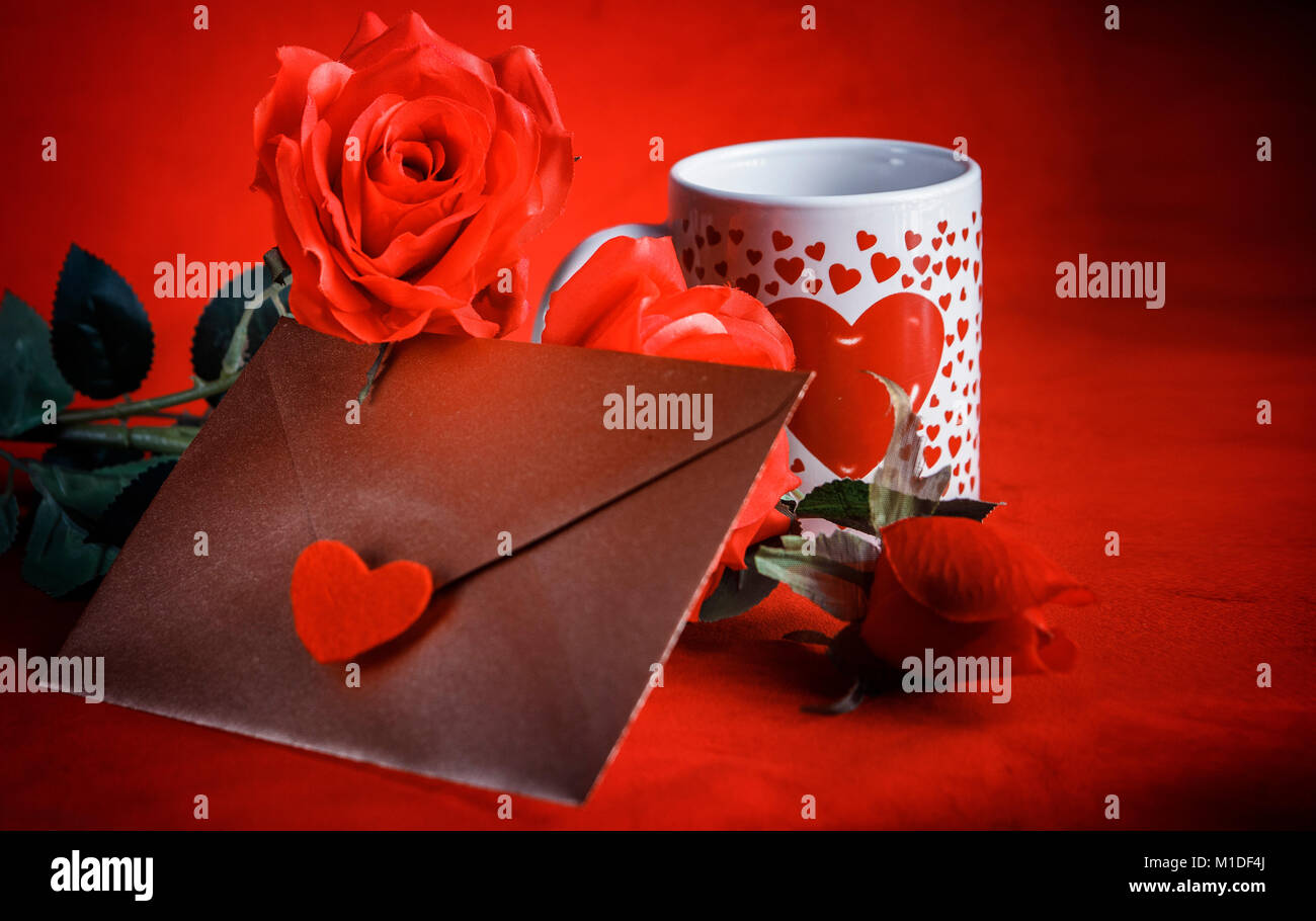Valentine concept, love letter, rose and a heart cup on a red ...