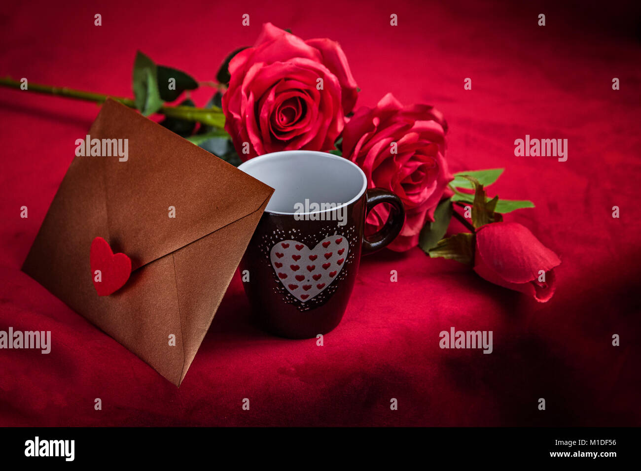 Valentine concept, love letter, rose and a heart cup on a red ...