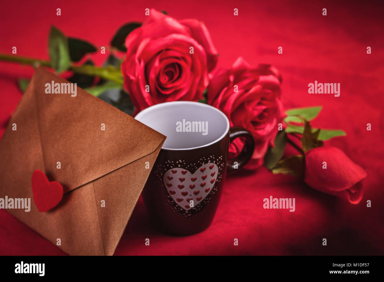 Valentine concept, love letter, rose and a heart cup on a red ...
