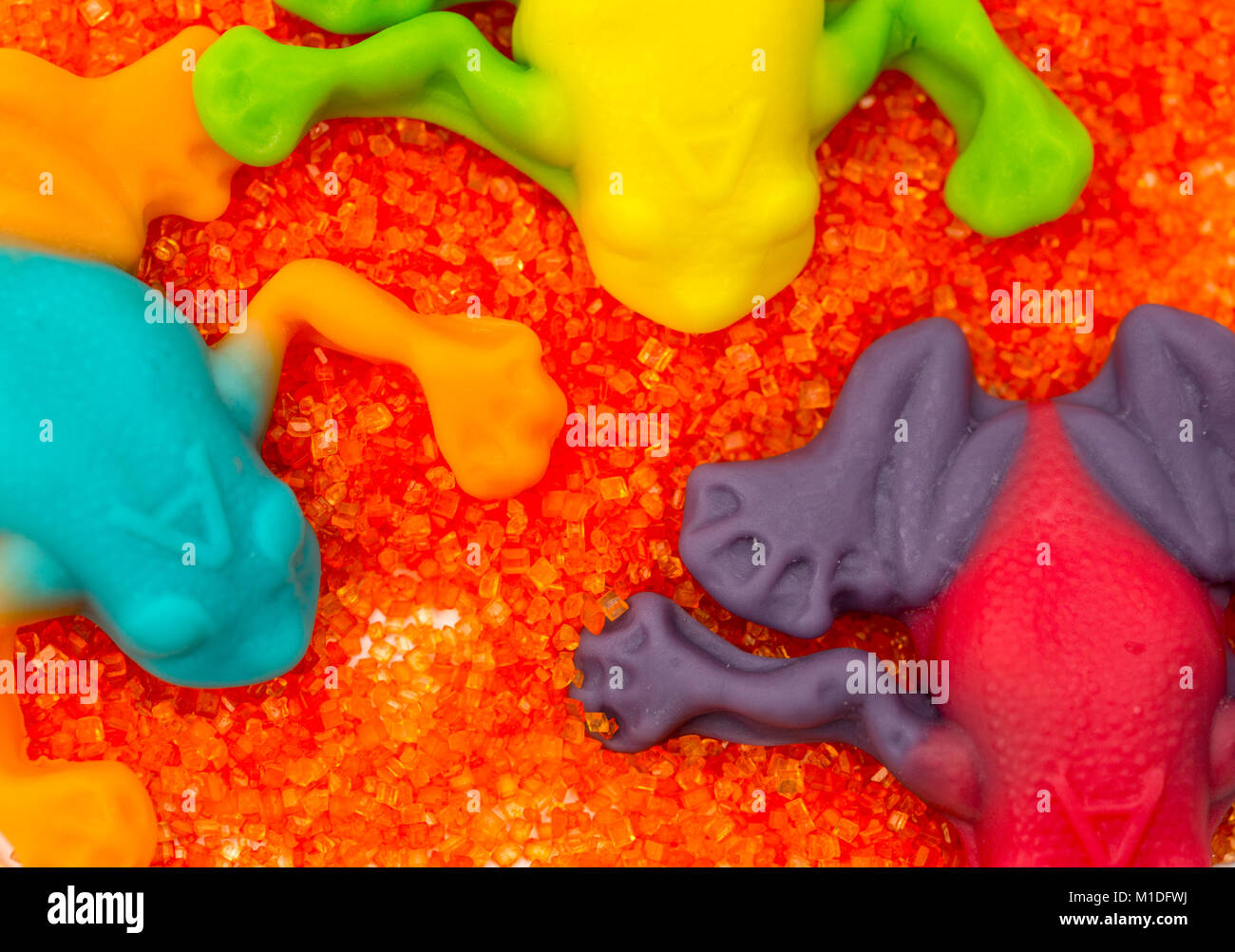 Gummy frog candies on a bed of orange sprinkles Stock Photo - Alamy