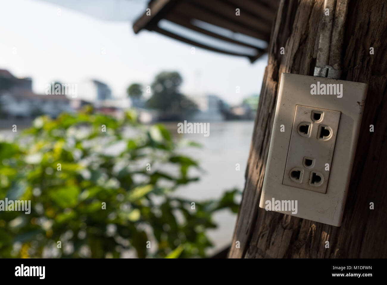 Asian old electric plug with multiple socket outside on wooden wall ...