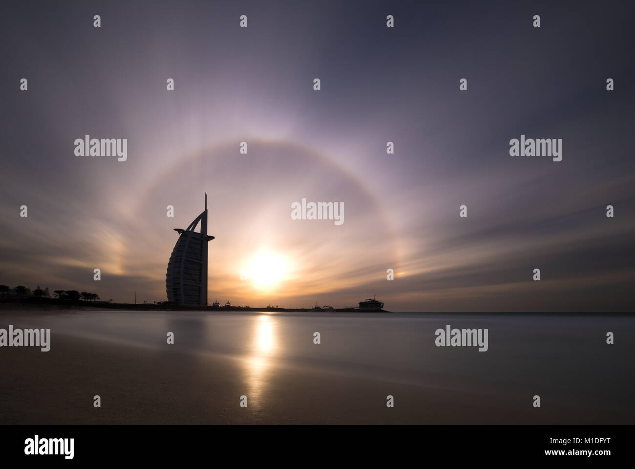 Dubai skyline during a colorful sunset with a rare sun halo as viewed ...