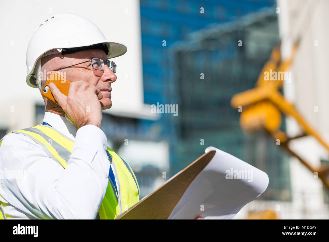 Man architector outdoor at construction area having mobile conversation ...