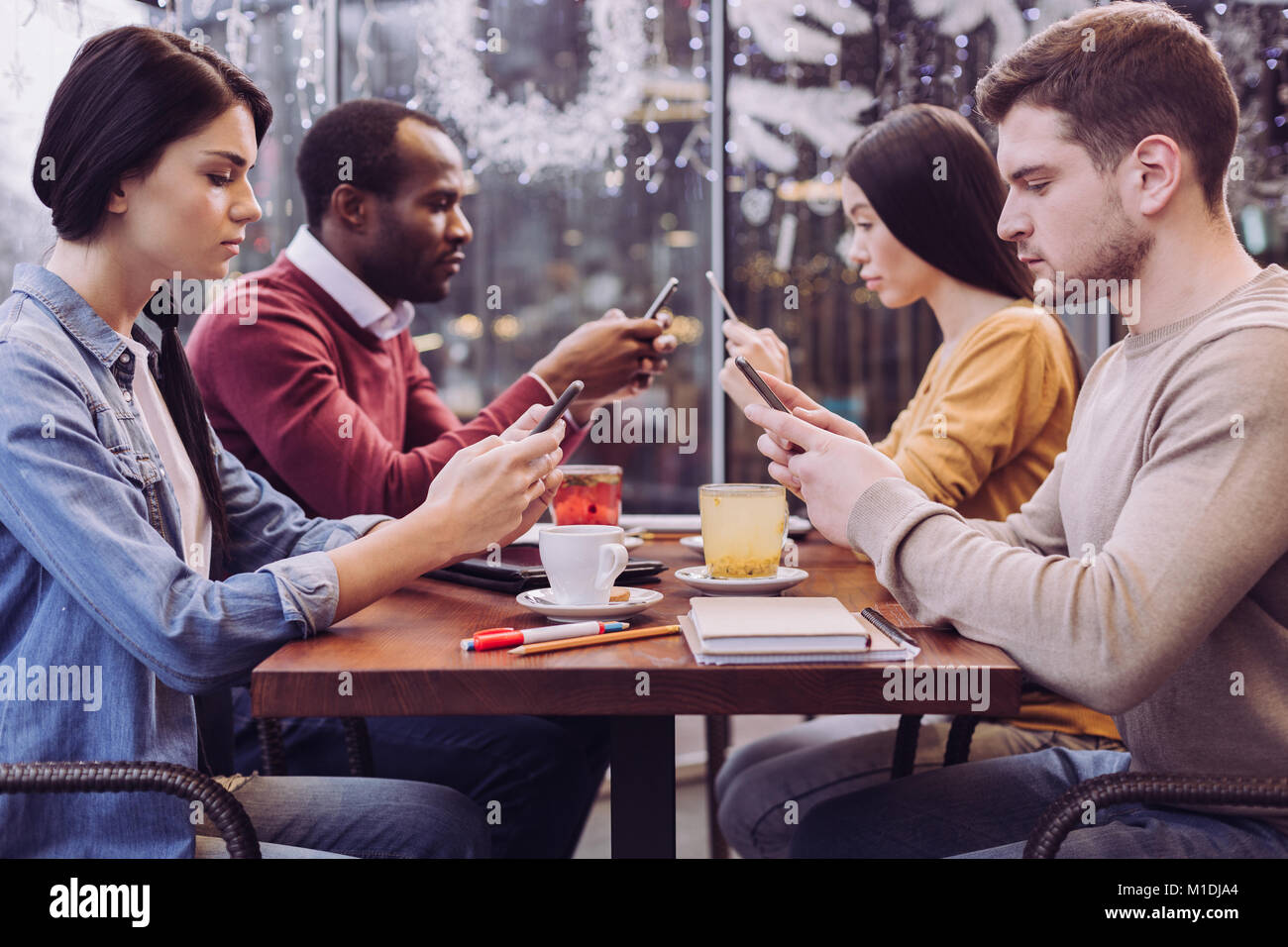 People staring at their mobile phones hi-res stock photography and ...