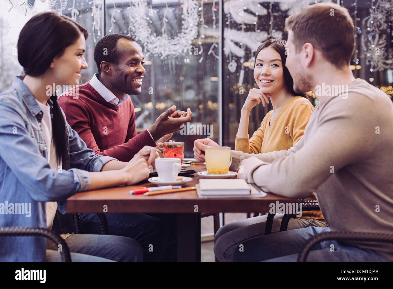 Cheerful four friends chatting together Stock Photo - Alamy