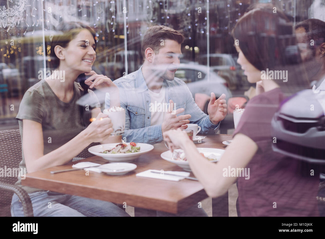 Cheerful three friends eating together Stock Photo - Alamy