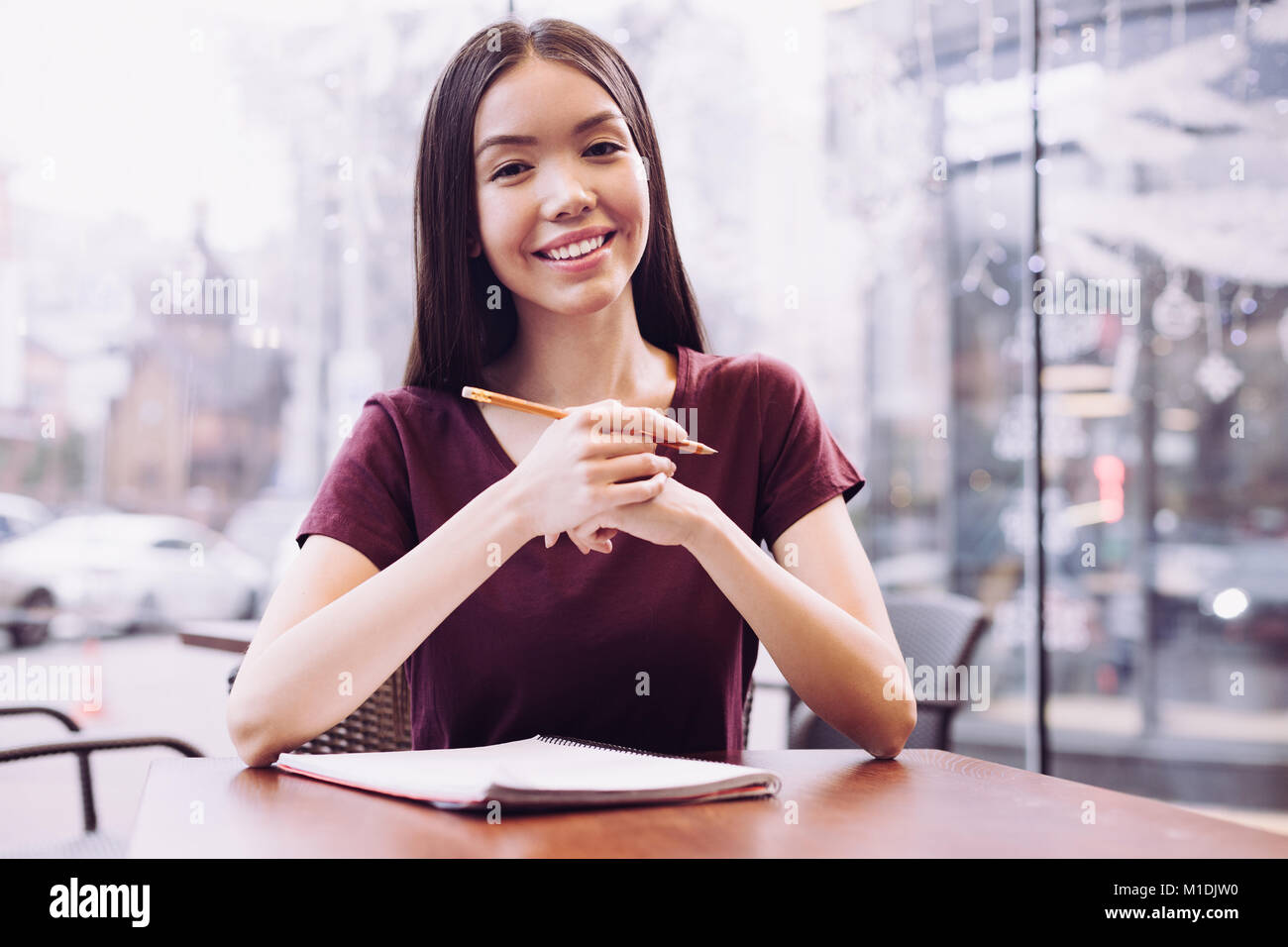 Positive female student doing task Stock Photo - Alamy