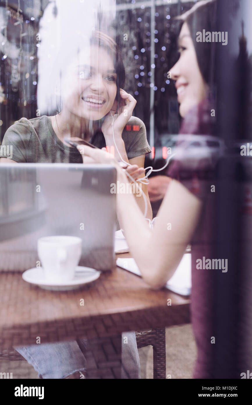 Optimistic two students listening to song Stock Photo - Alamy