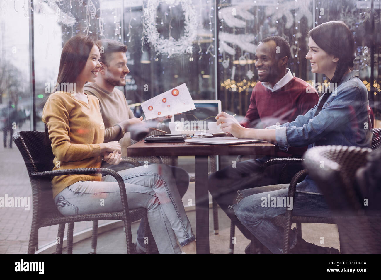 Optimistic four colleagues presenting plan Stock Photo - Alamy
