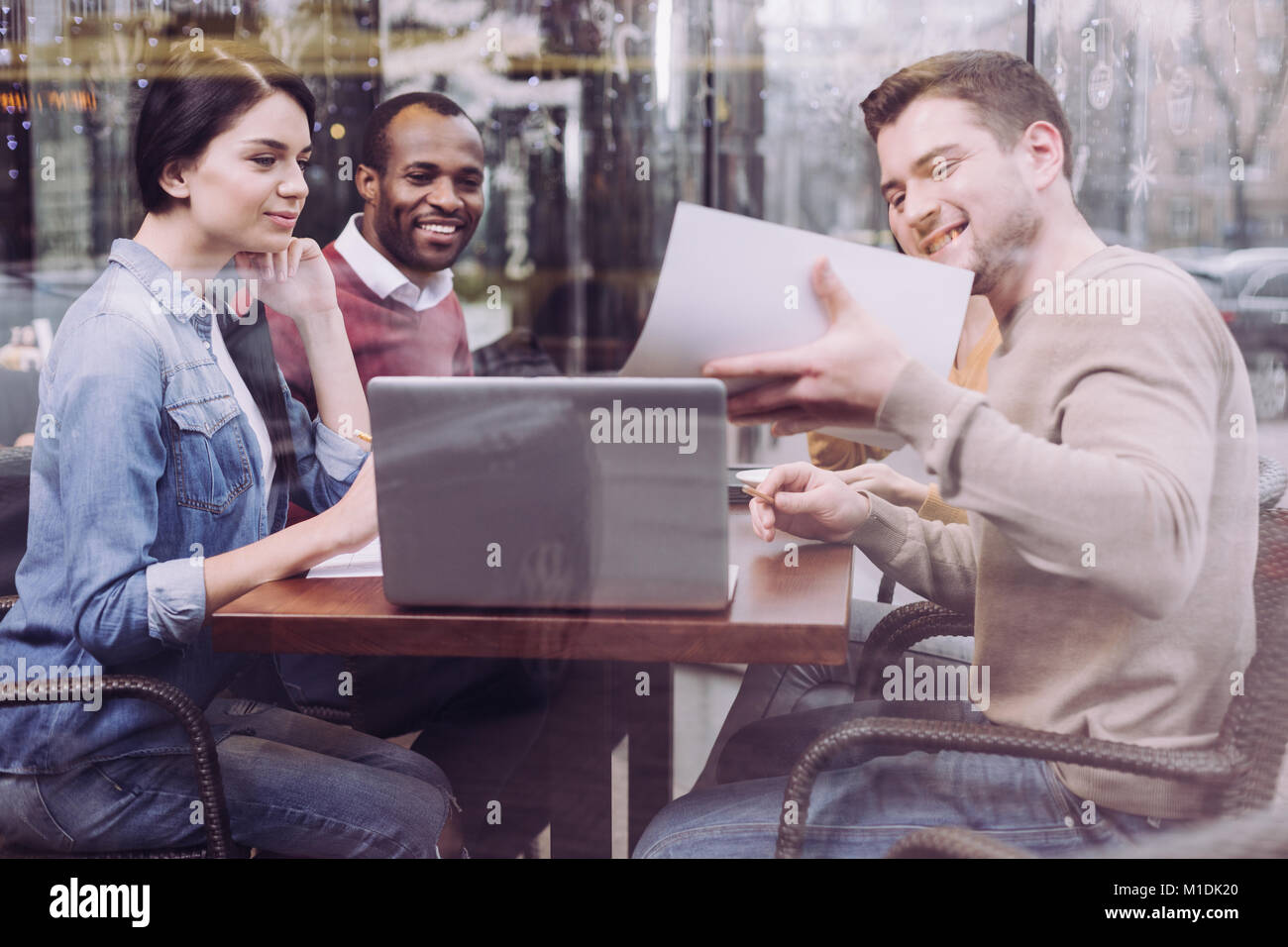 Joyful three colleagues looking at statistics Stock Photo - Alamy