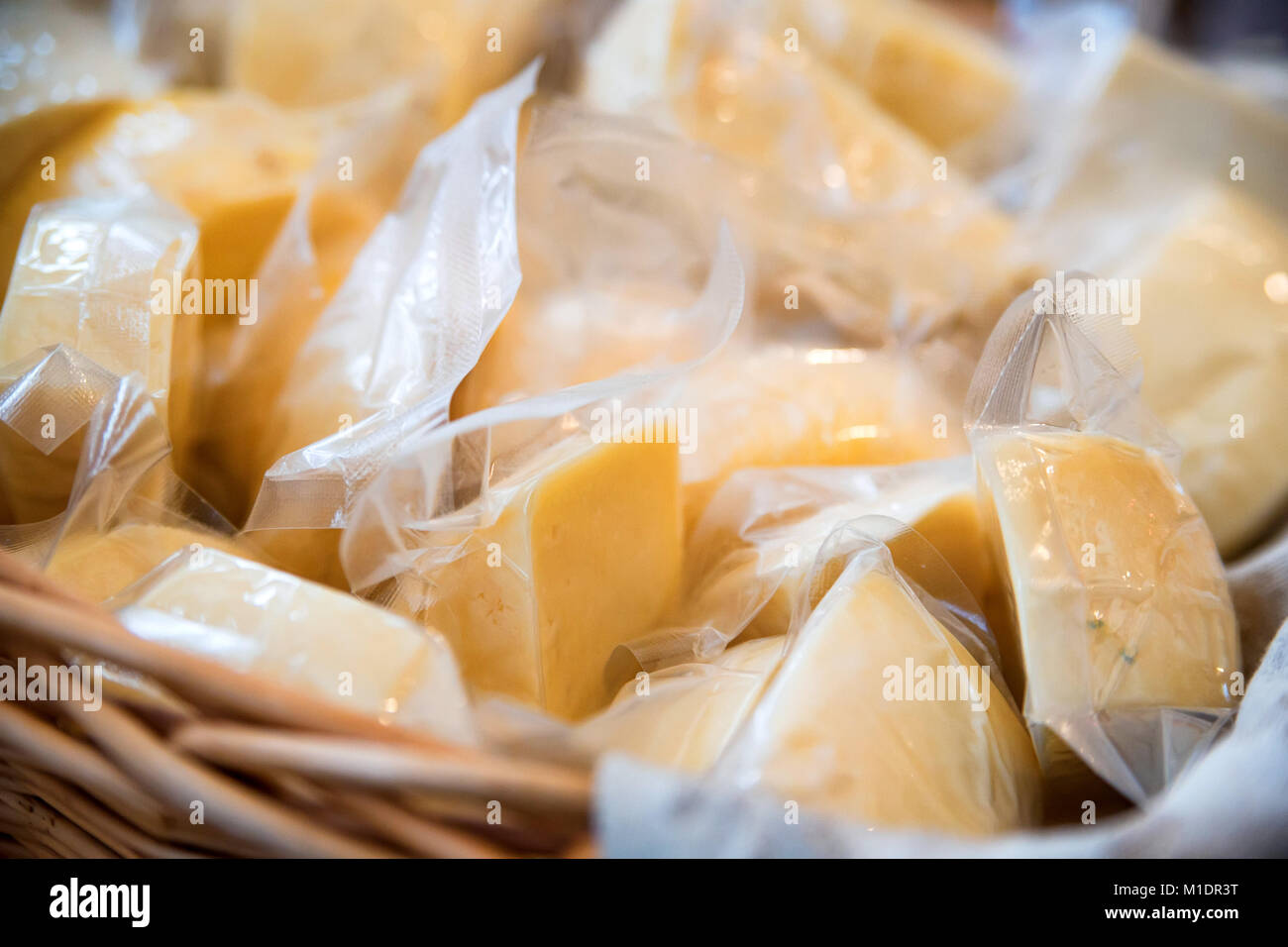 Cheese pieces in plastic package in shop close Stock Photo - Alamy