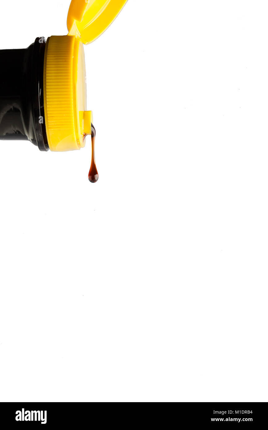 Drop of syrup with it's bottle on white background Stock Photo - Alamy
