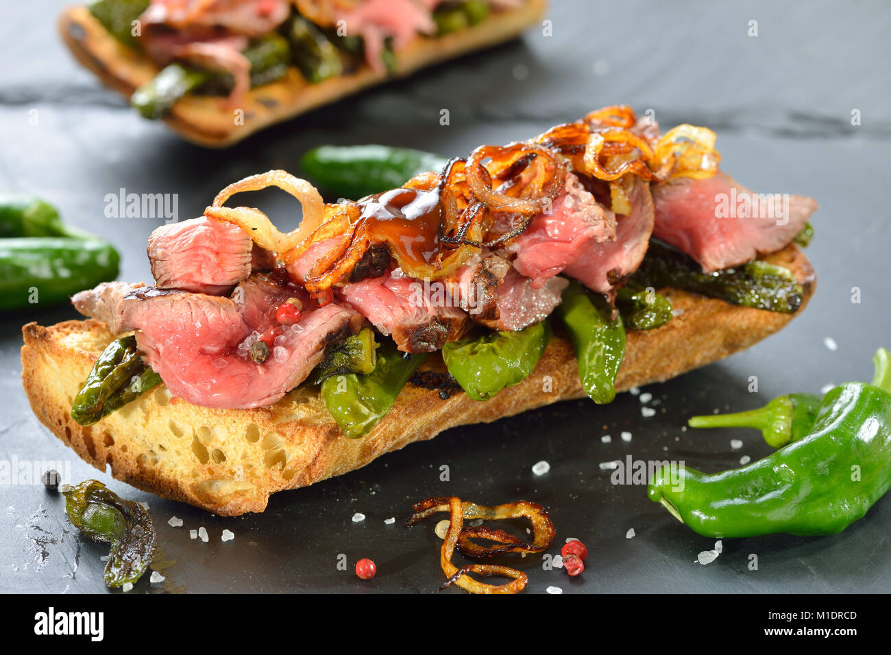 Street food: Hot Panini topped with fried pimentos, grilled beef steak ...