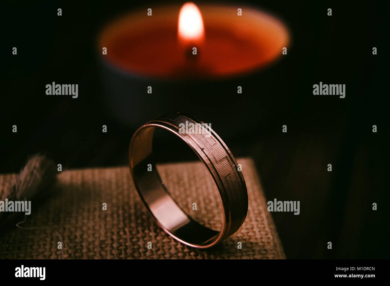 Wedding ring and burning candle background Stock Photo - Alamy