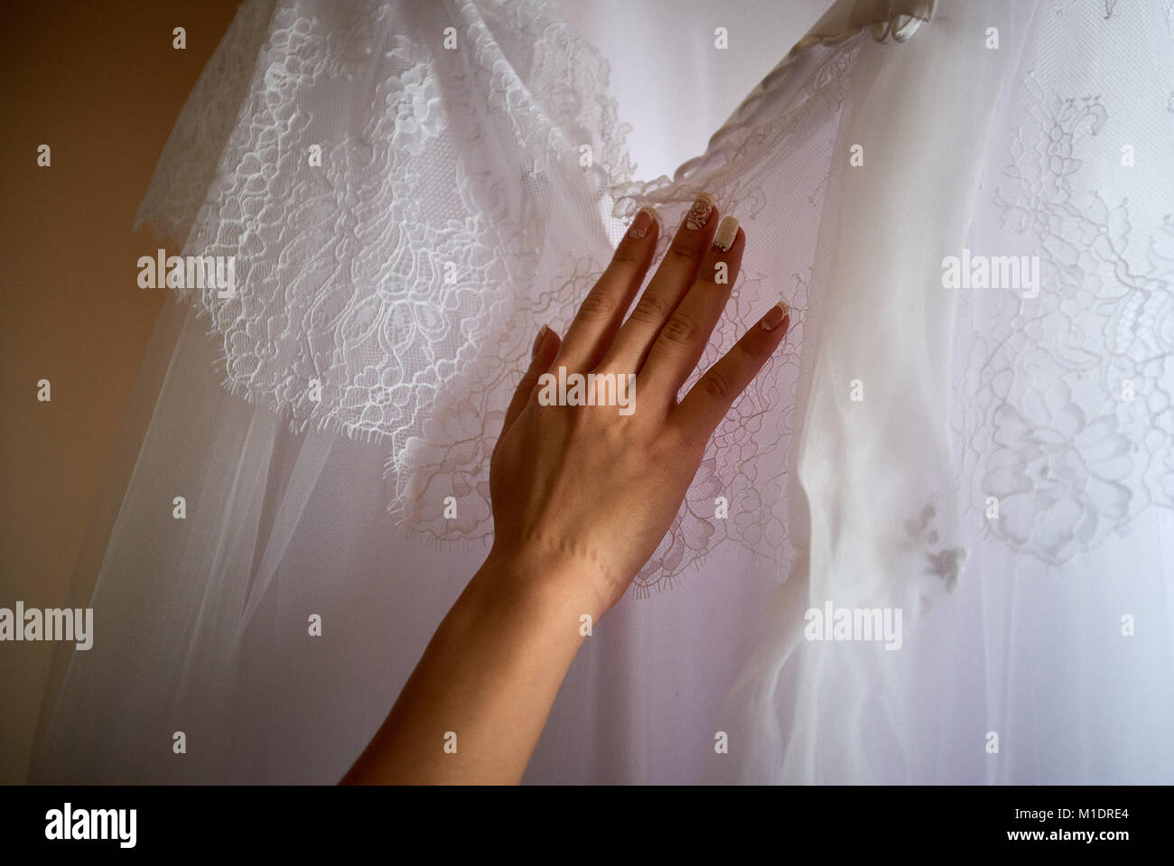 Female hand touches wedding dress close up Stock Photo - Alamy