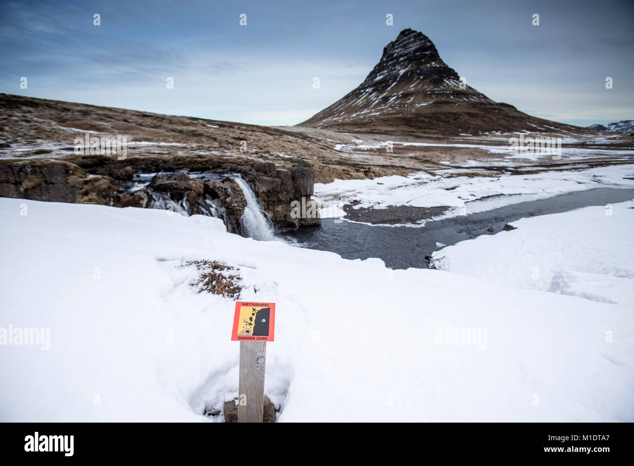Warning sign at Kirkjufellsfoss waterfall, a popular tourist ...
