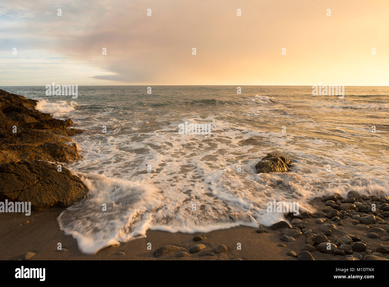 The calm sea in a very cloudy sunset in Spain Stock Photo - Alamy