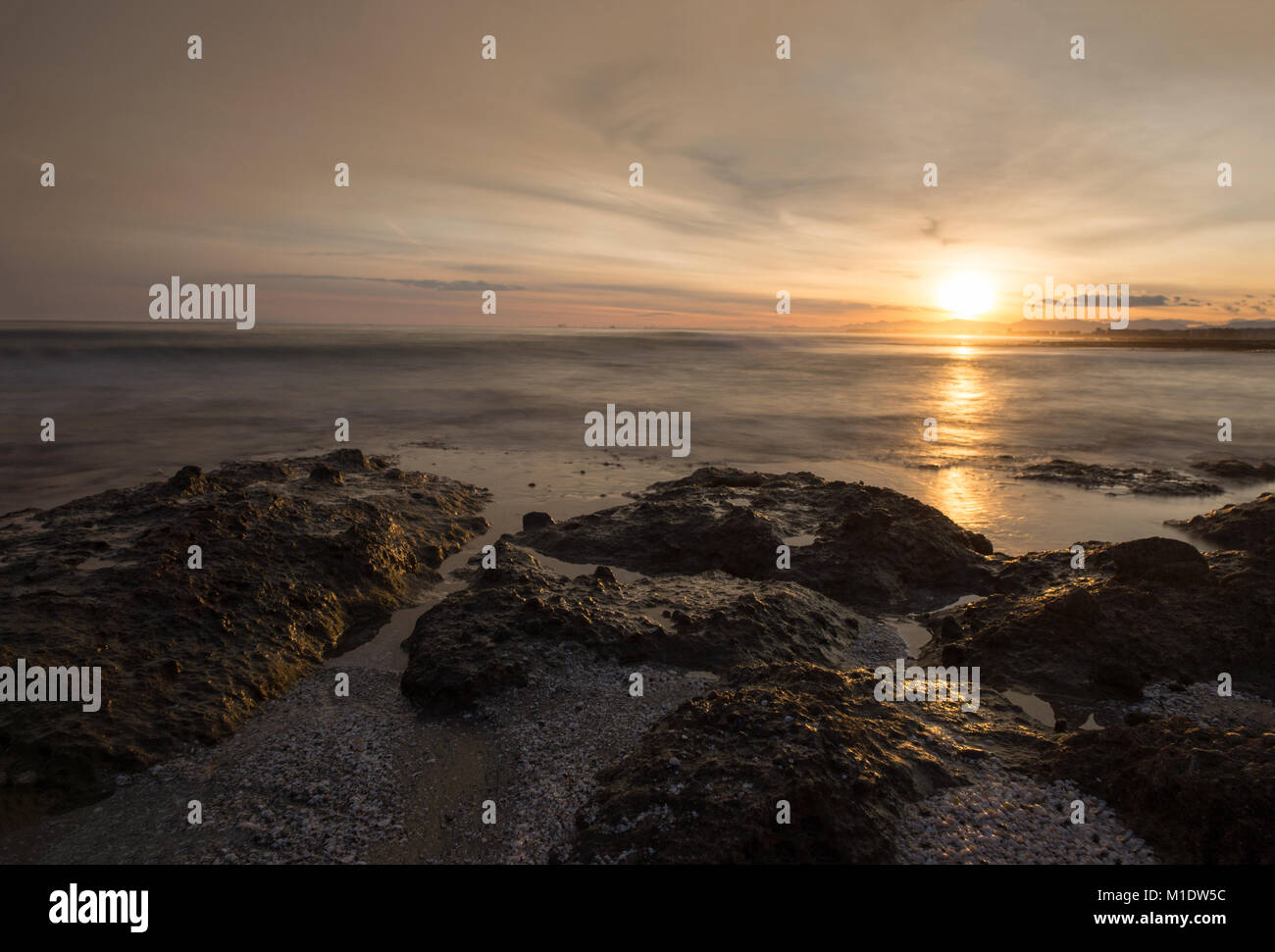 The calm sea in a very cloudy sunset in Spain Stock Photo - Alamy