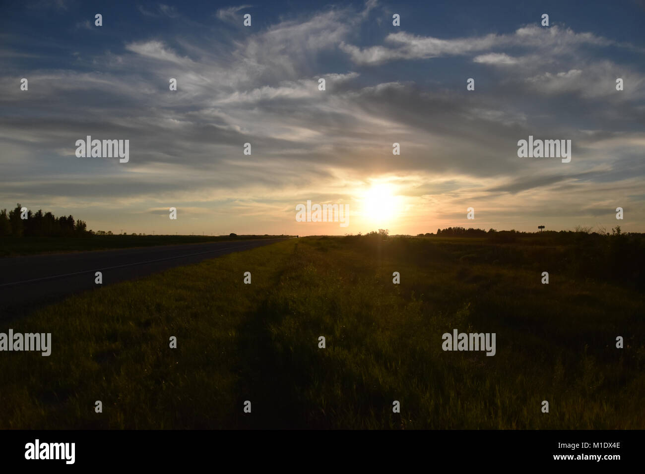 Sunset alongside a highway with big prairie skies, Eastern Saskatchewan ...