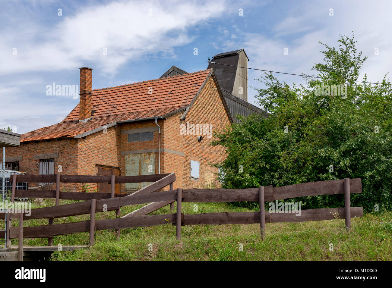 Old abandoned brick building behind a wooden fence Stock Photo - Alamy